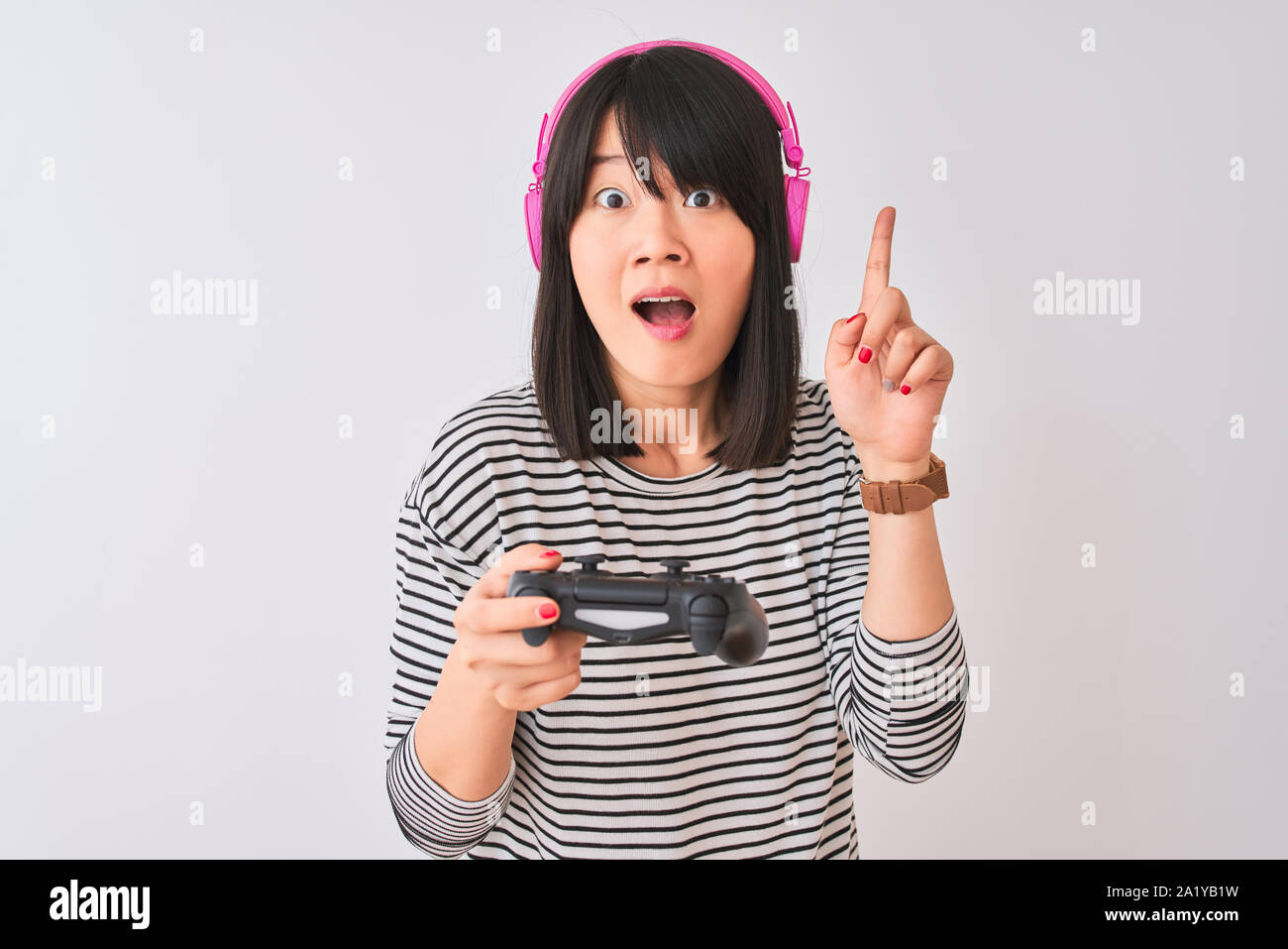 Chinese gamer woman playing video game using headphones over isolated ...