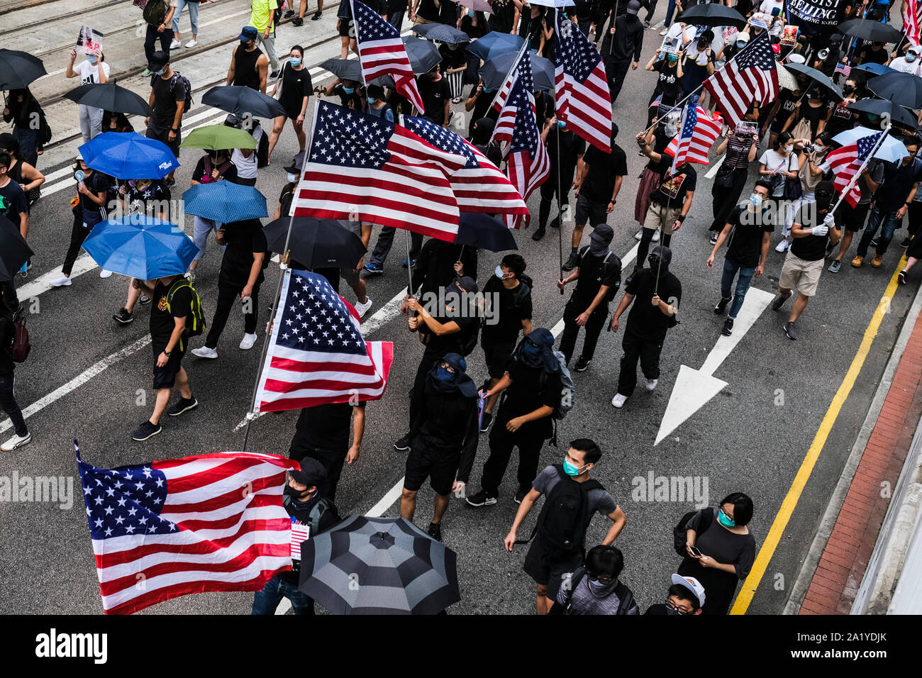 Protesters march with US flags and umbrellas during the demonstration ...