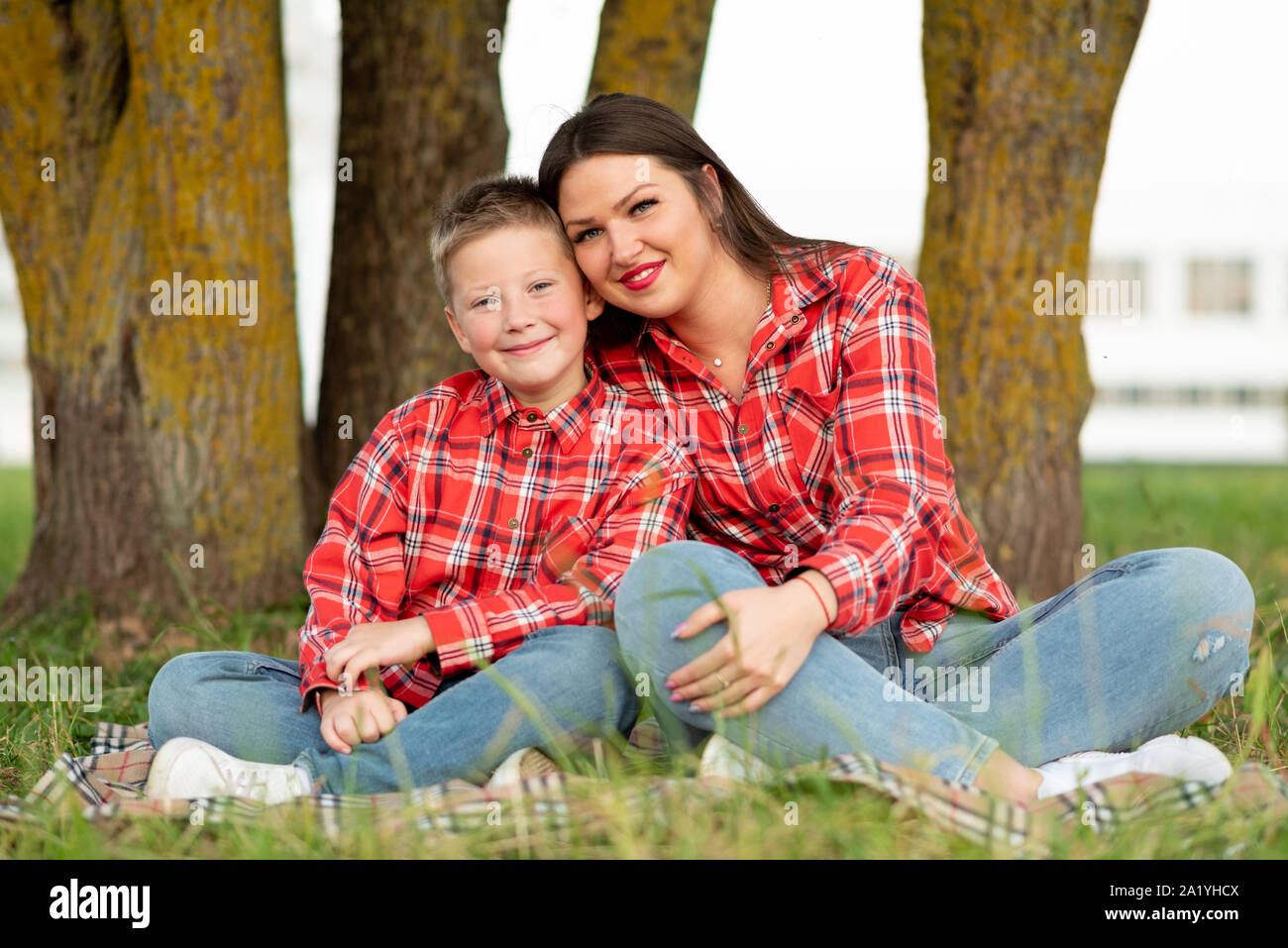 Mom And Son Sitting On The Bedspread In Lotus Position Hugging Stock