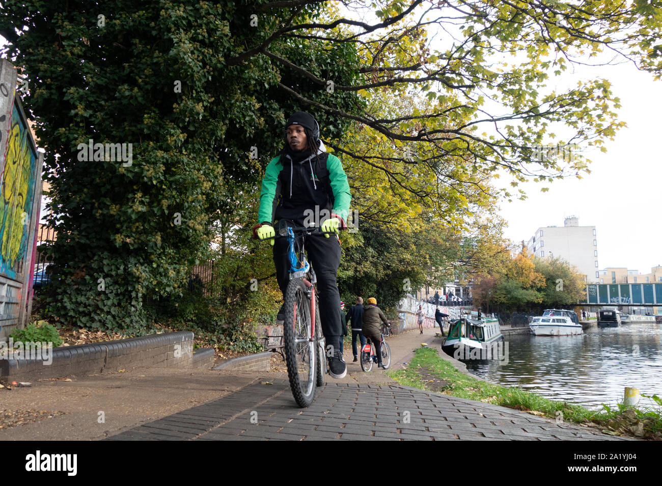 Commuter cycles along towpath on london canal hi-res stock photography ...