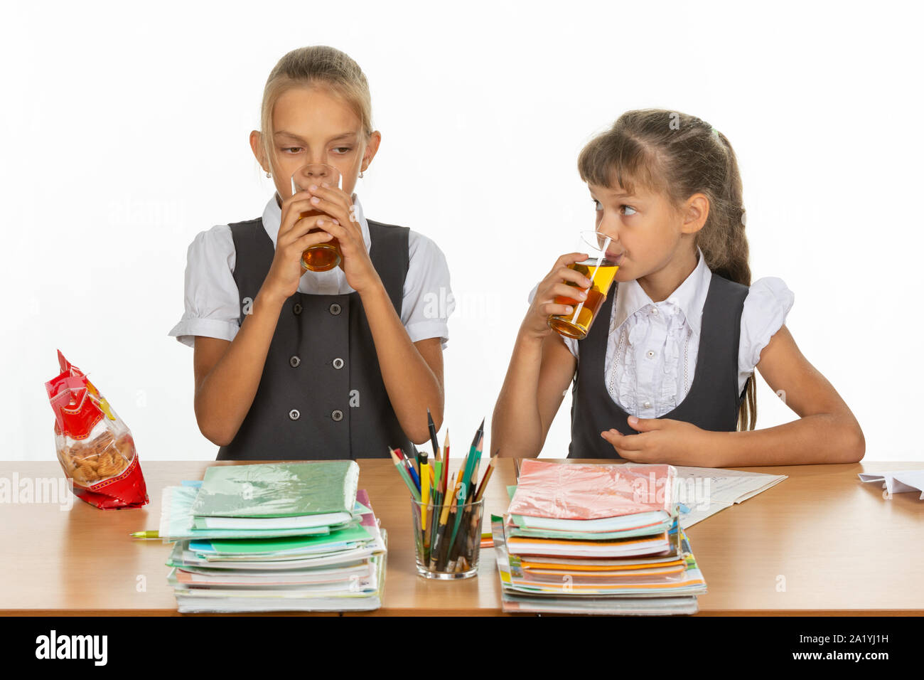 Two school friends drink juice at a table in a school class Stock Photo ...