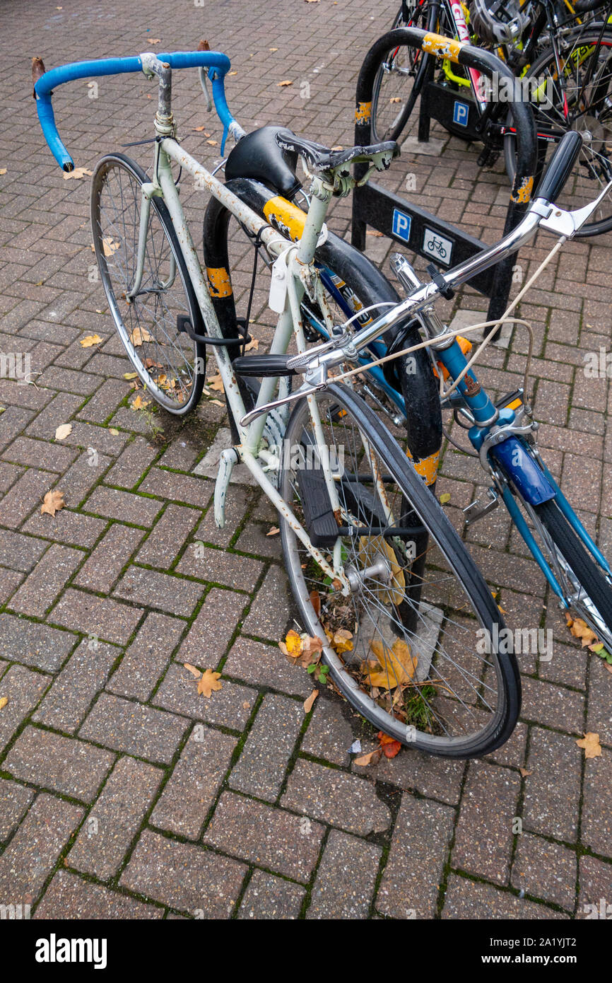 2 damaged bikes with broken wheels chained up Stock Photo - Alamy