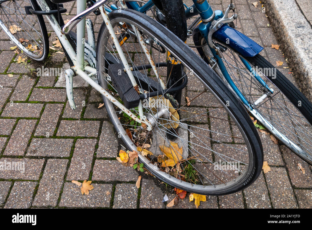 2 damaged bikes with broken wheels chained up hi-res stock photography ...
