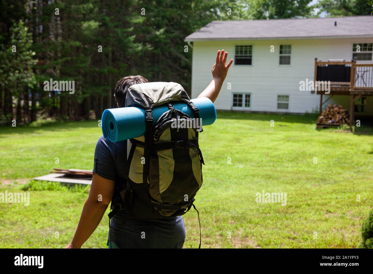 person loking back at their house with a backpack ready for adventure ...