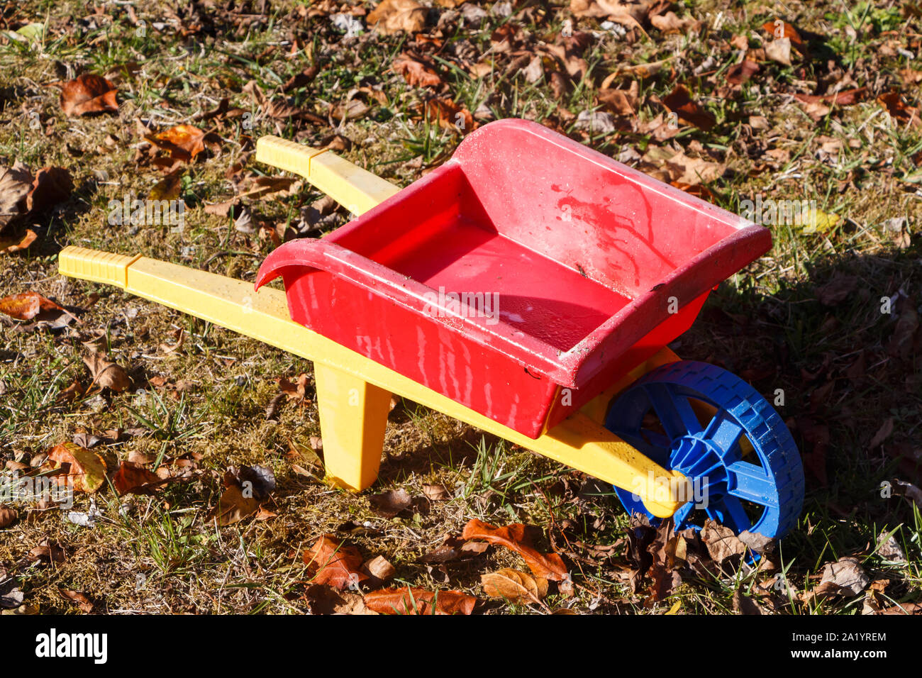 Outdoor toy, red and yellow wheelbarrow in plastic Stock Photo - Alamy