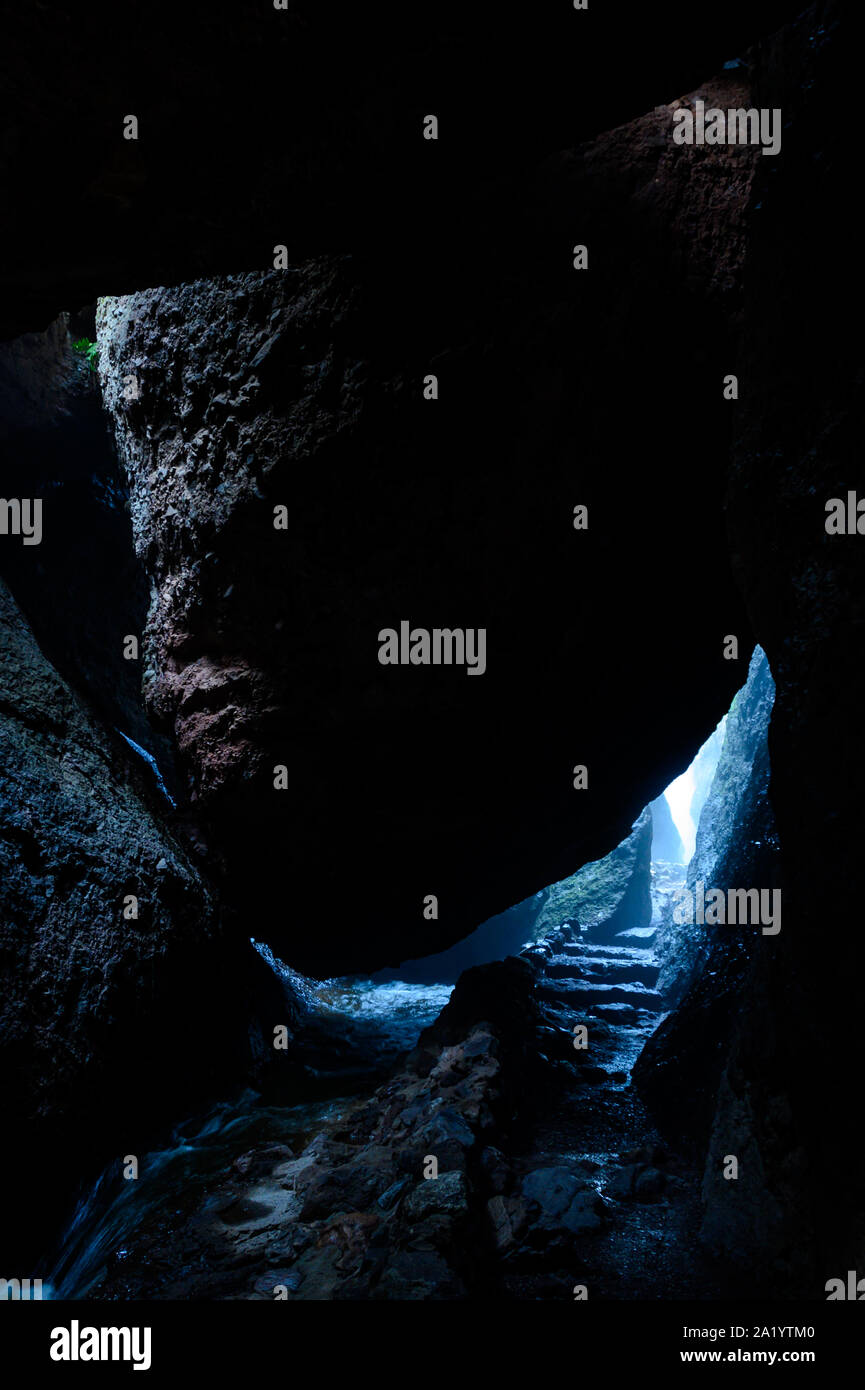 Light Glows Over Trail Through Tunnel below boulder Stock Photo - Alamy