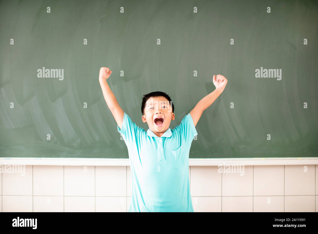 happy school boy standing against chalkboard background Stock Photo - Alamy