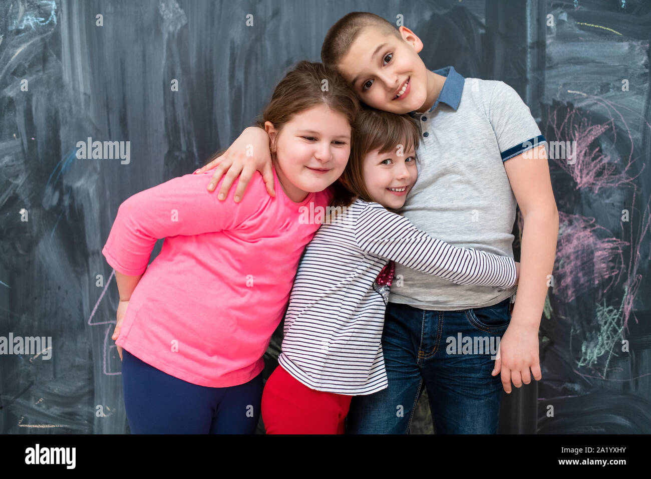 group portrait of happy kids hugging each other while having fun in ...