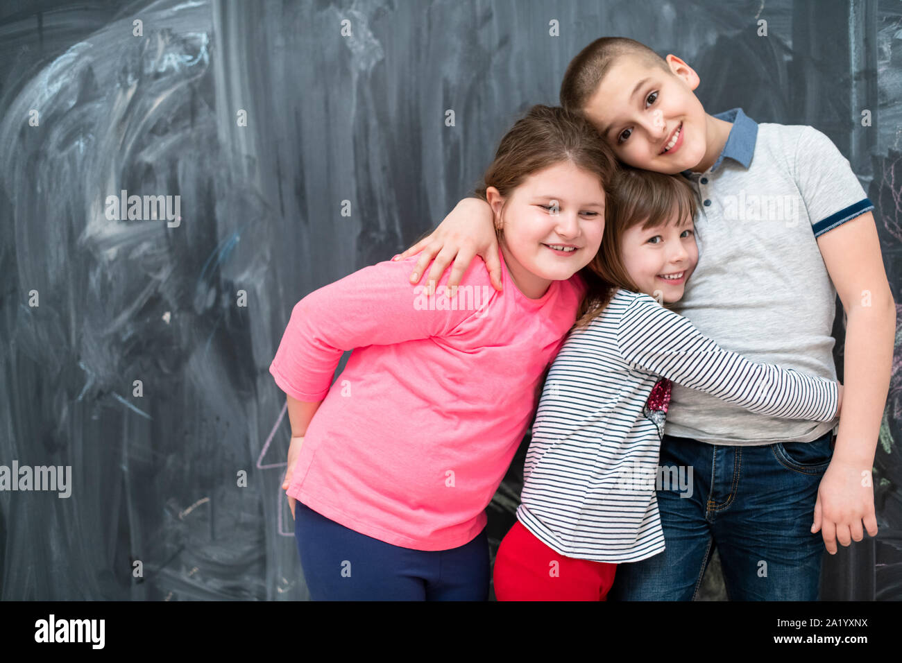 group portrait of happy kids hugging each other while having fun in ...