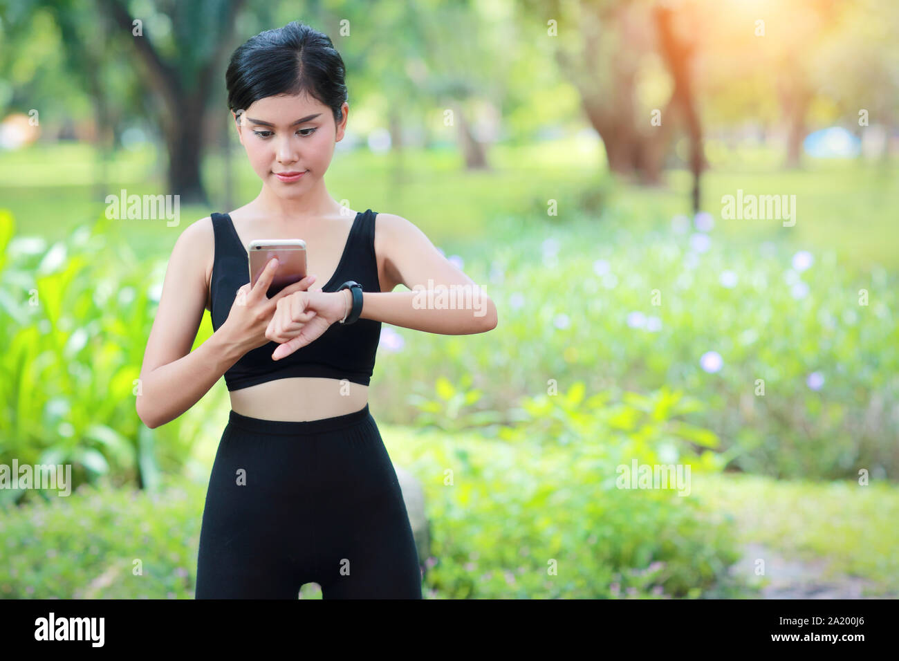sport girl holding smart phone and checking smart watch Stock Photo - Alamy