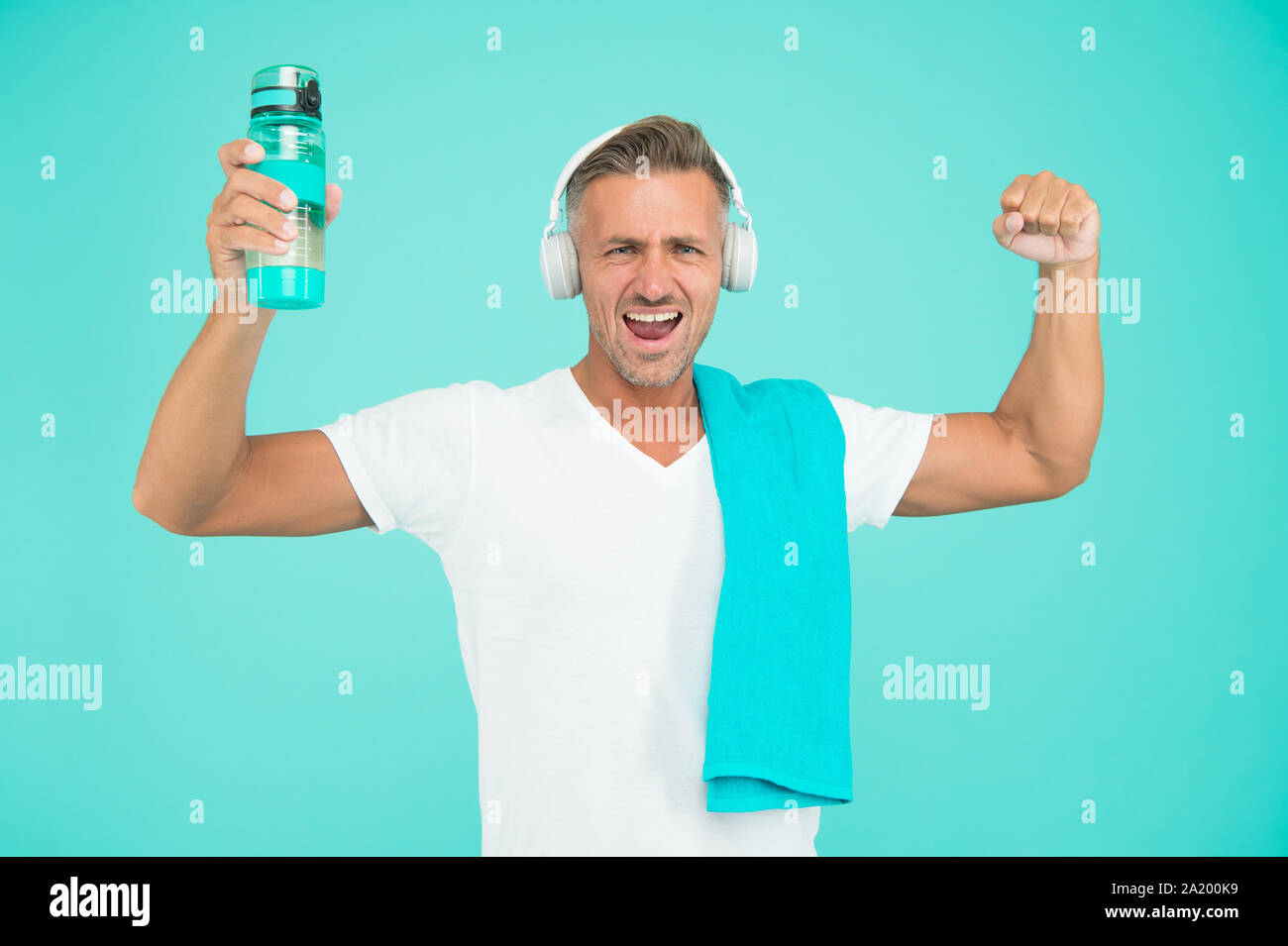 Staying hydrated staying healthy. Healthy and strong man on blue ...