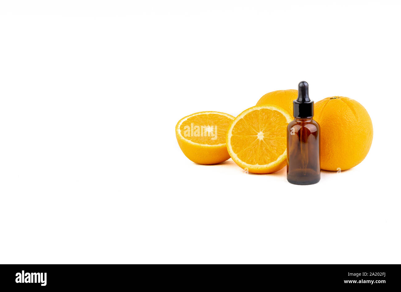 Vitamin C serum bottle with dropper and orange on white background ...