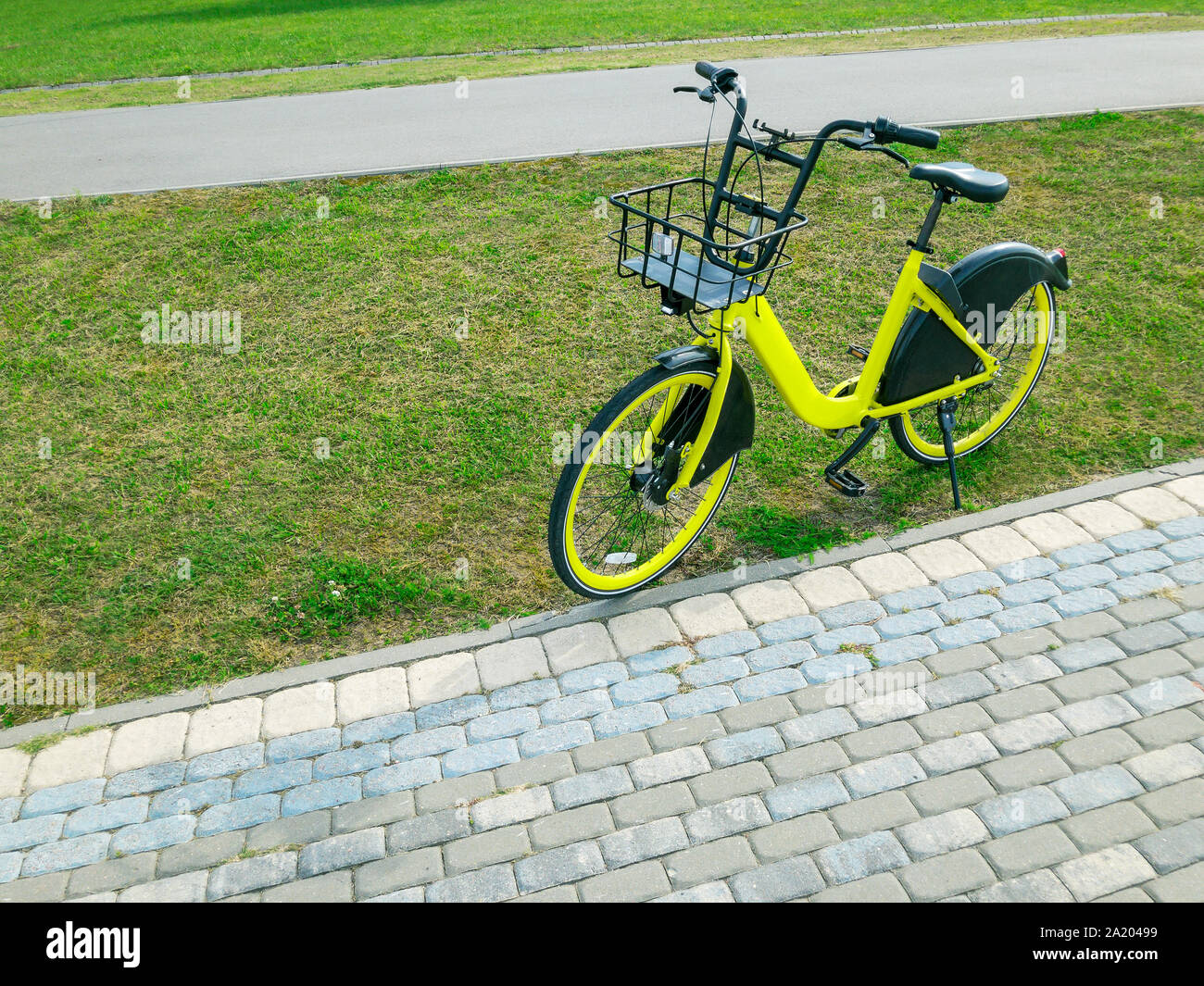 parked yellow rent-a-bike near sidewalk. ecological transport for ...