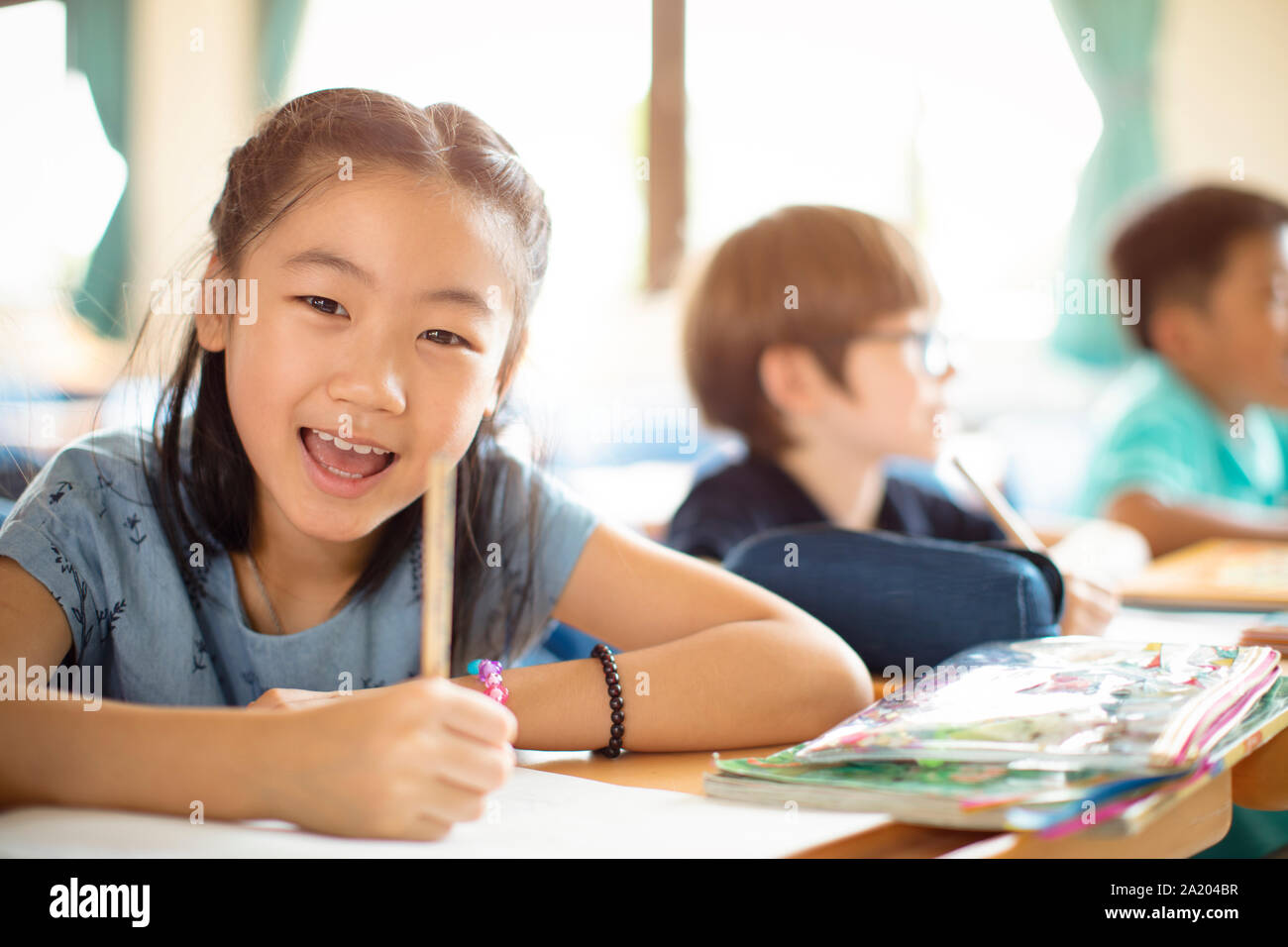 Smiling elementary school kids in classroom Stock Photo - Alamy