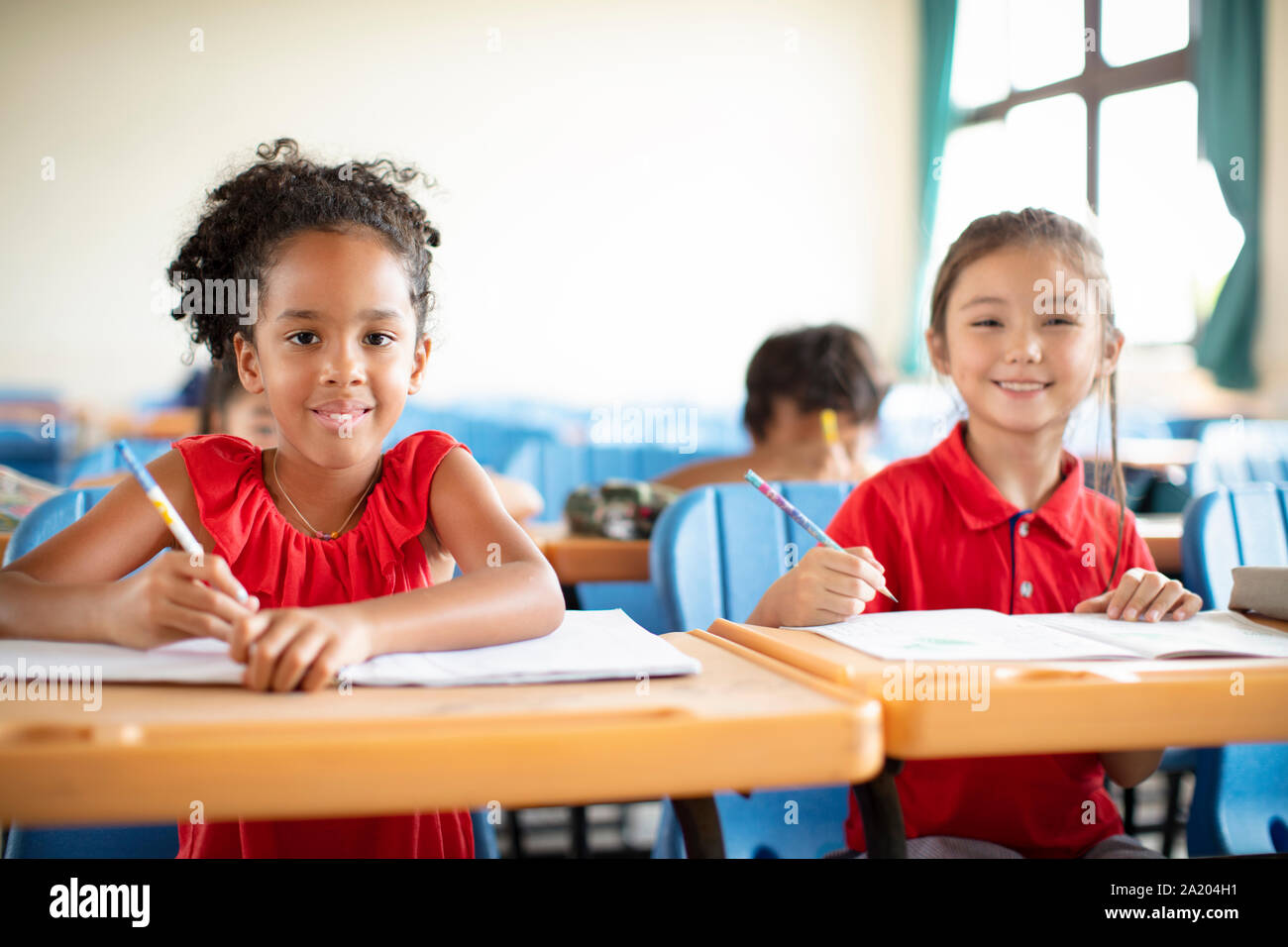 Smiling elementary school kids in classroom Stock Photo - Alamy