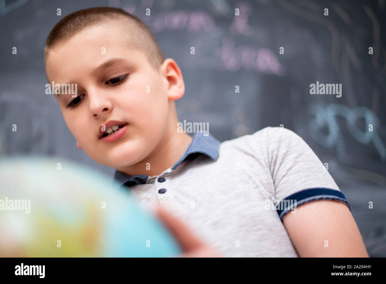 happy cute boy learning about the world using globe of earth while ...