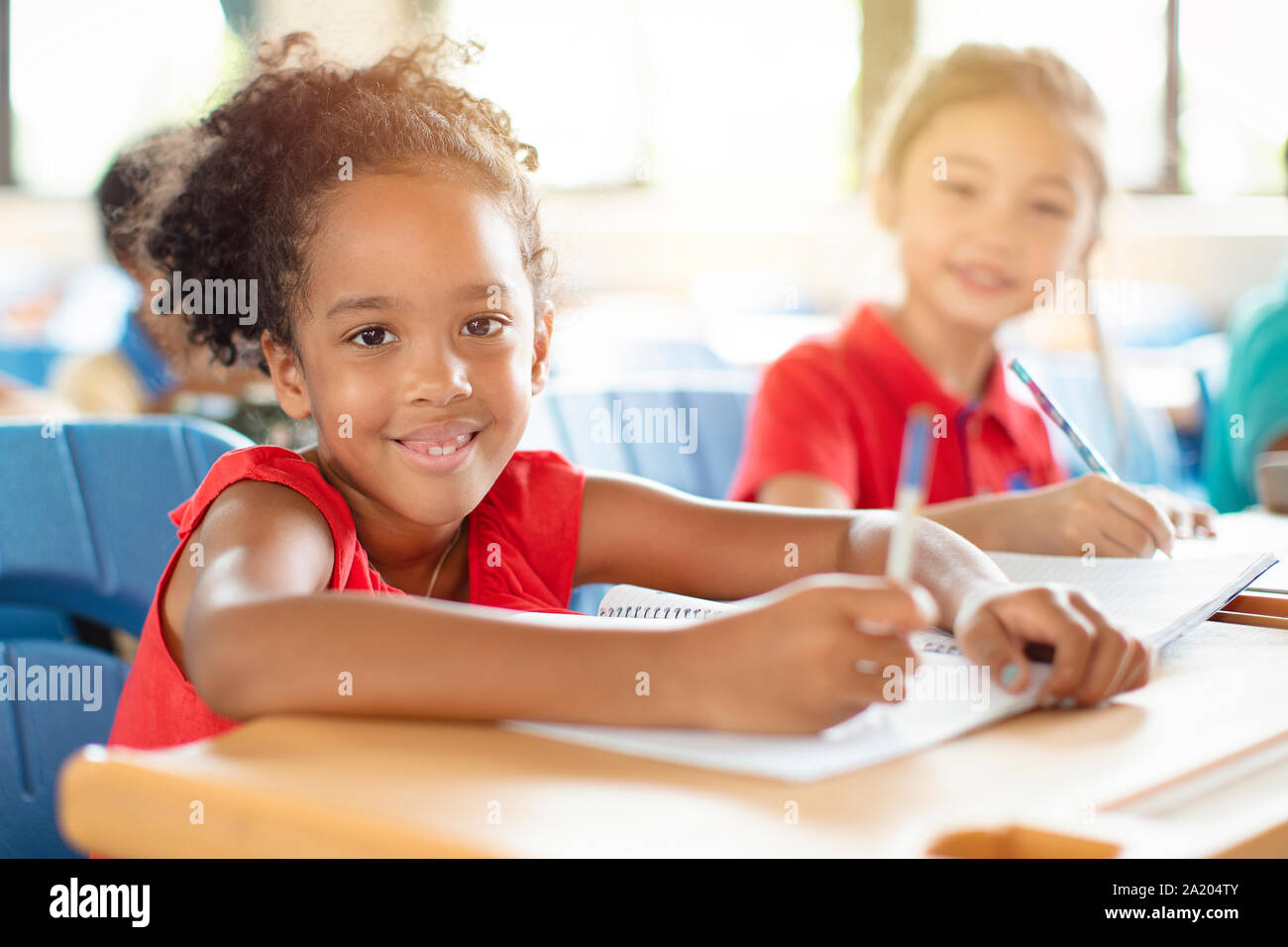 Smiling elementary school kids in classroom Stock Photo - Alamy