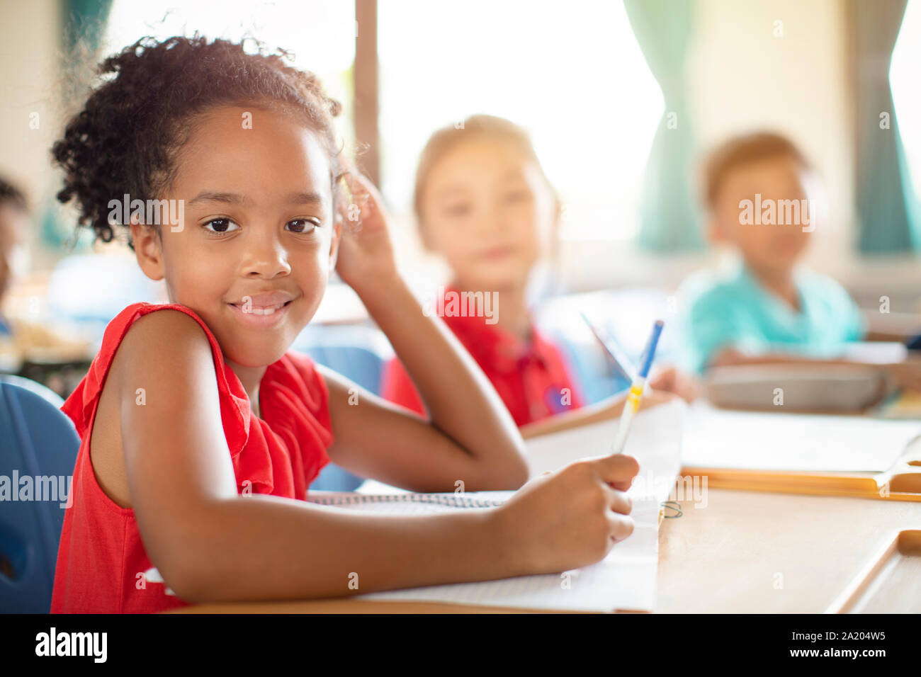 Smiling elementary school kids in classroom Stock Photo - Alamy