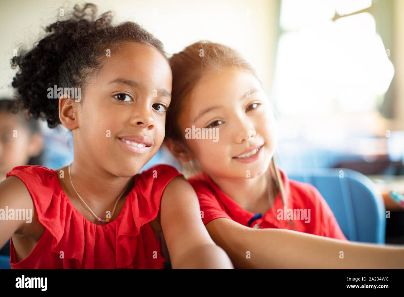 Smiling elementary school kids in classroom Stock Photo - Alamy