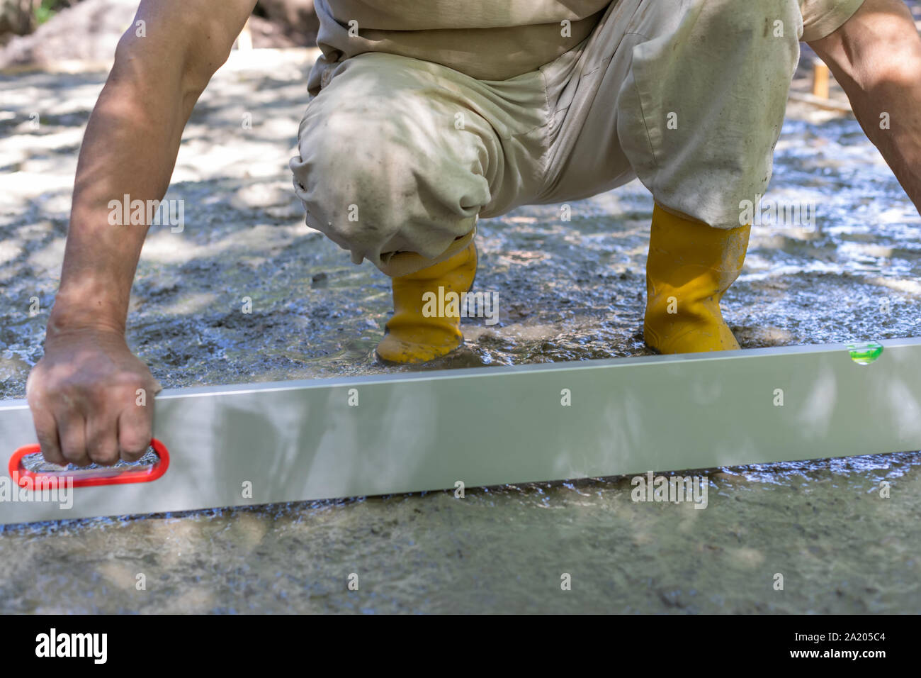Construction worker in yellow rubber boots at the construction site ...