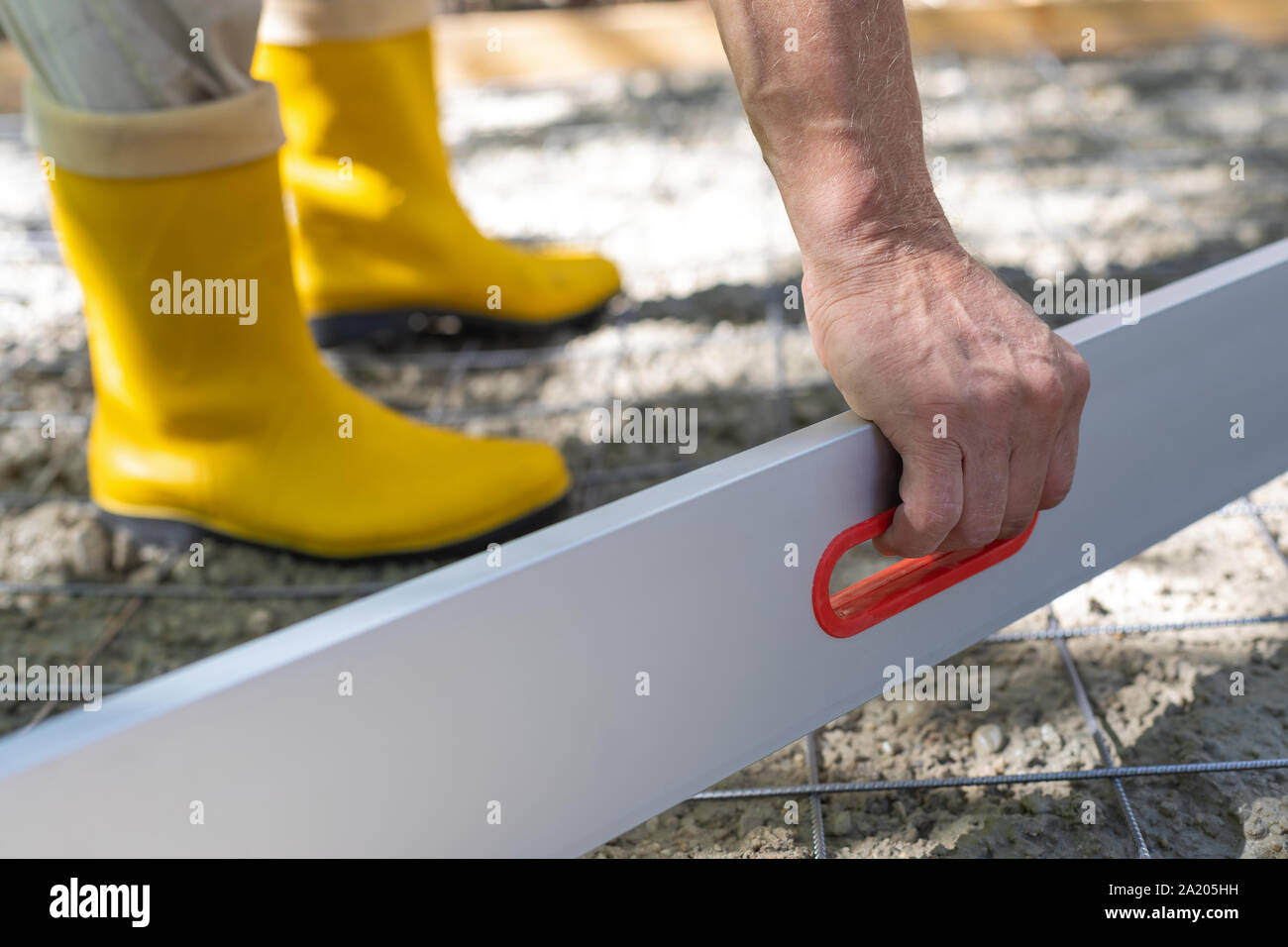 Construction worker in yellow rubber boots at the construction site ...