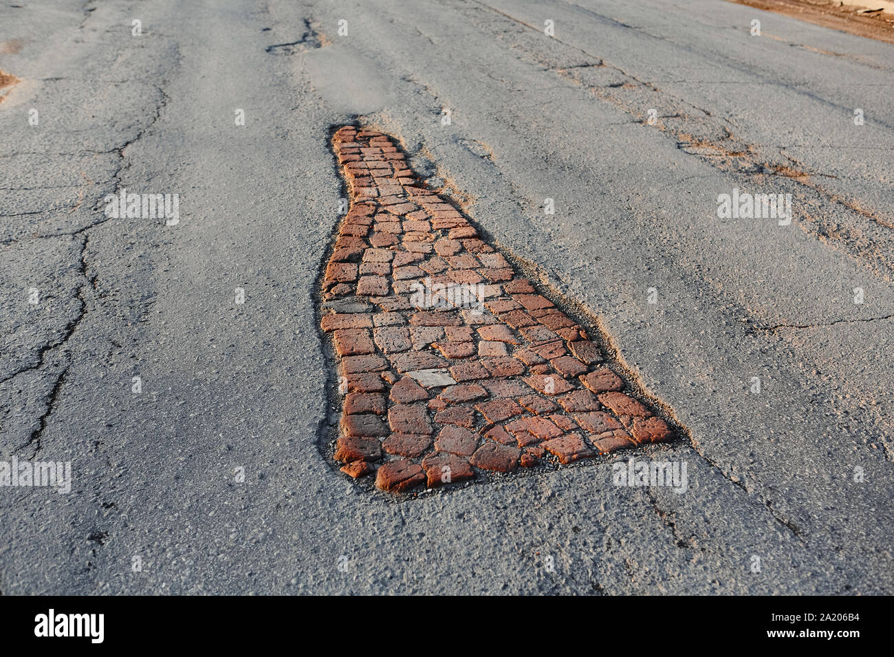 potholes in the road sealed with old bricks. Creative way to repair ...