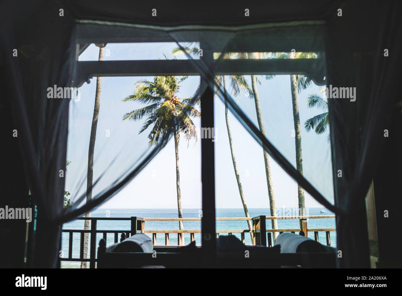 Tropical ocean and palm tree view through villa window in Bali. Leisure ...