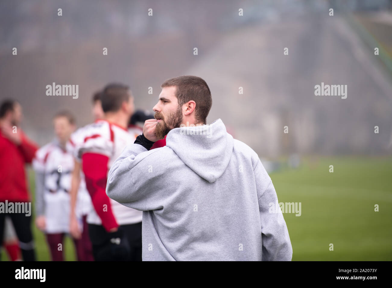 group of young american football players warming up and stretching ...