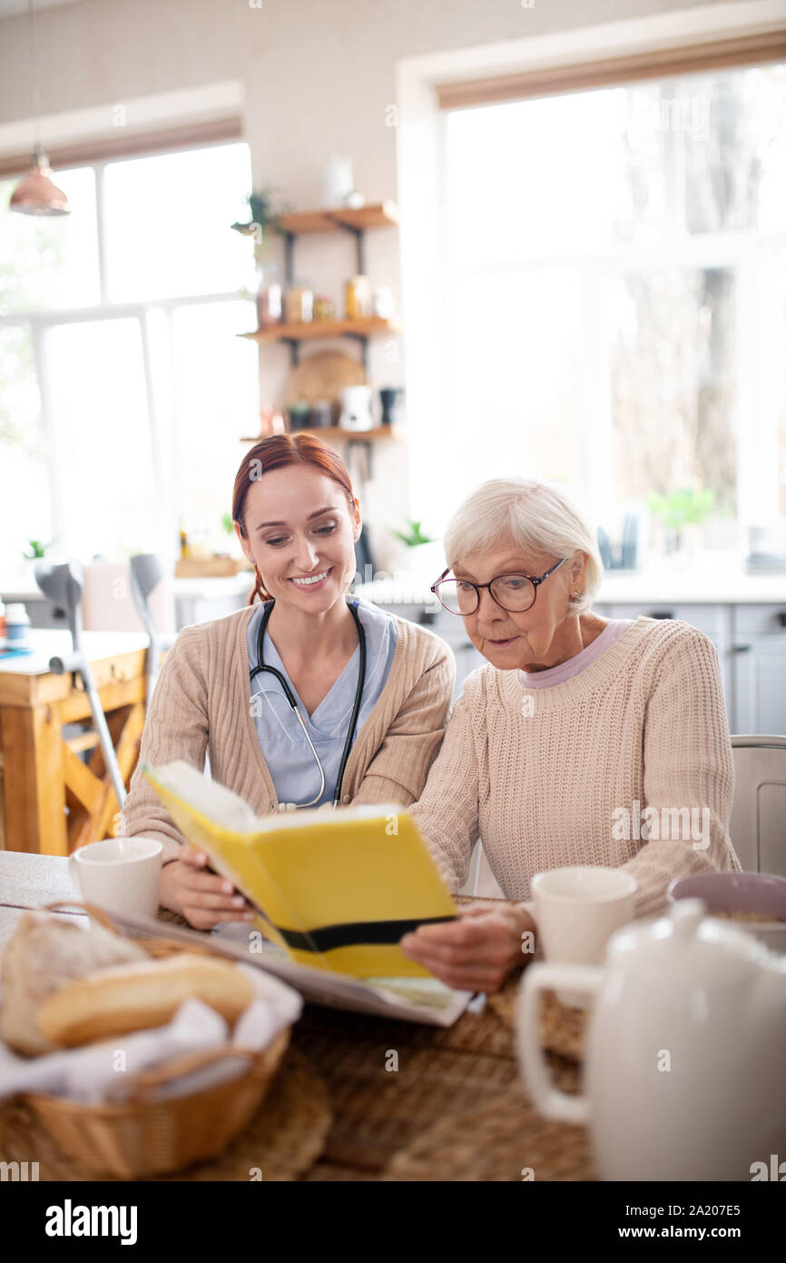 Nurse reading book senior woman hi-res stock photography and images - Alamy