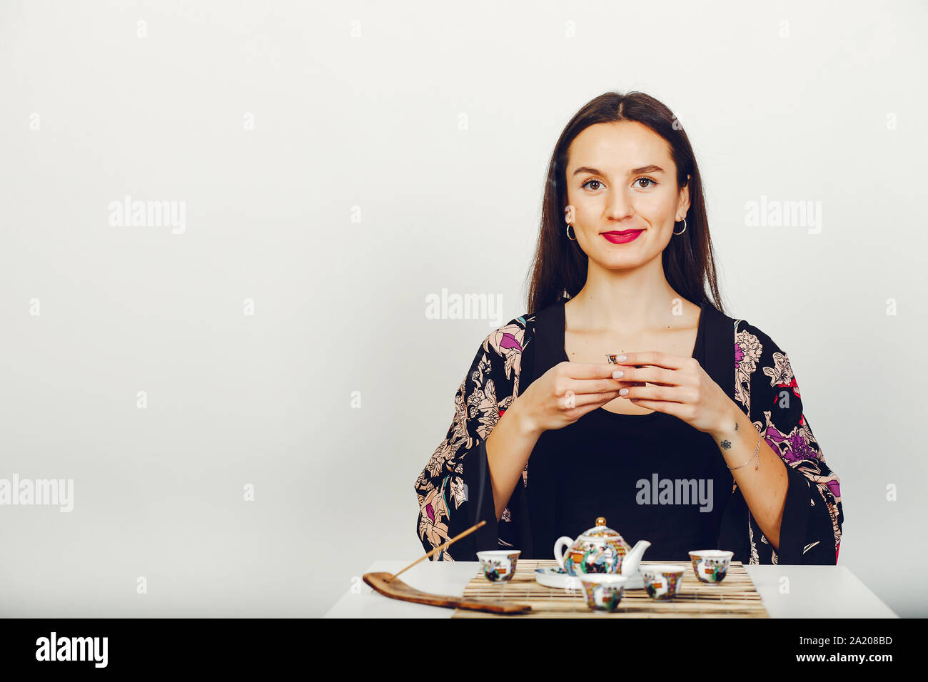 Beautiful girl drinking a tea in a studio Stock Photo - Alamy