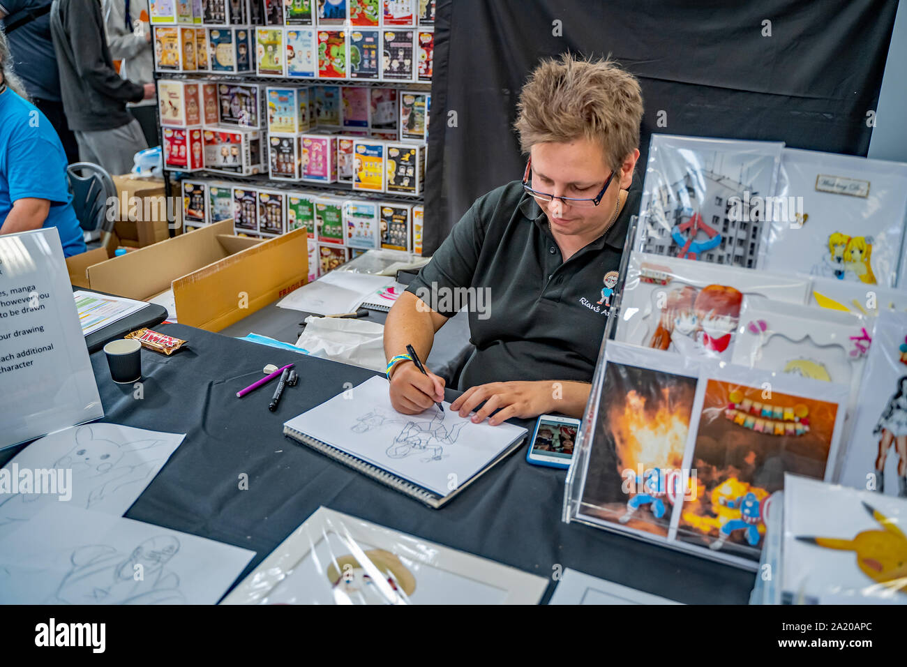 A male Managa cartoon artist demonstrating his drawing techniques and ...