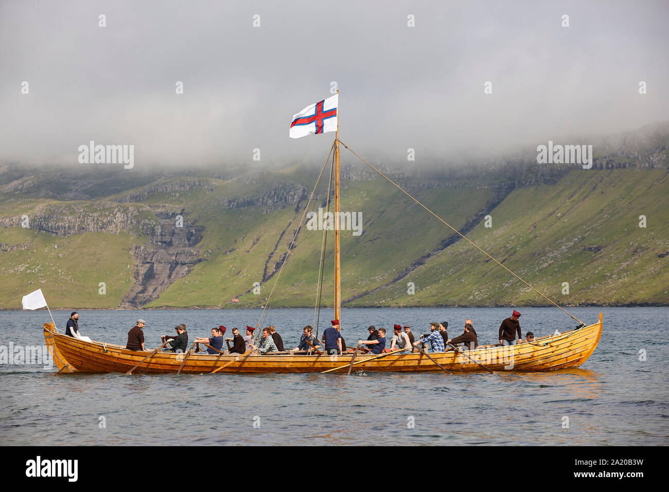 Traditional faroese wooden ship with paddlers on the fjord. Faroe Stock ...