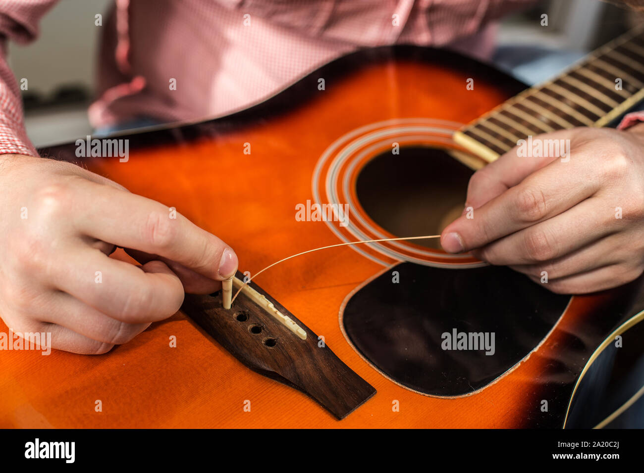 man changes hands old ripped guitar strings on the acoustic guitar on ...