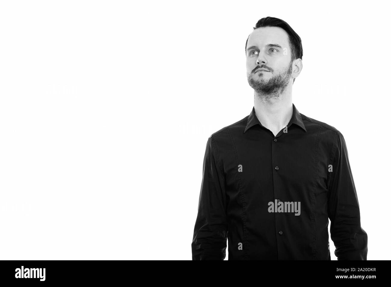 Studio shot of young man thinking while looking up Stock Photo - Alamy