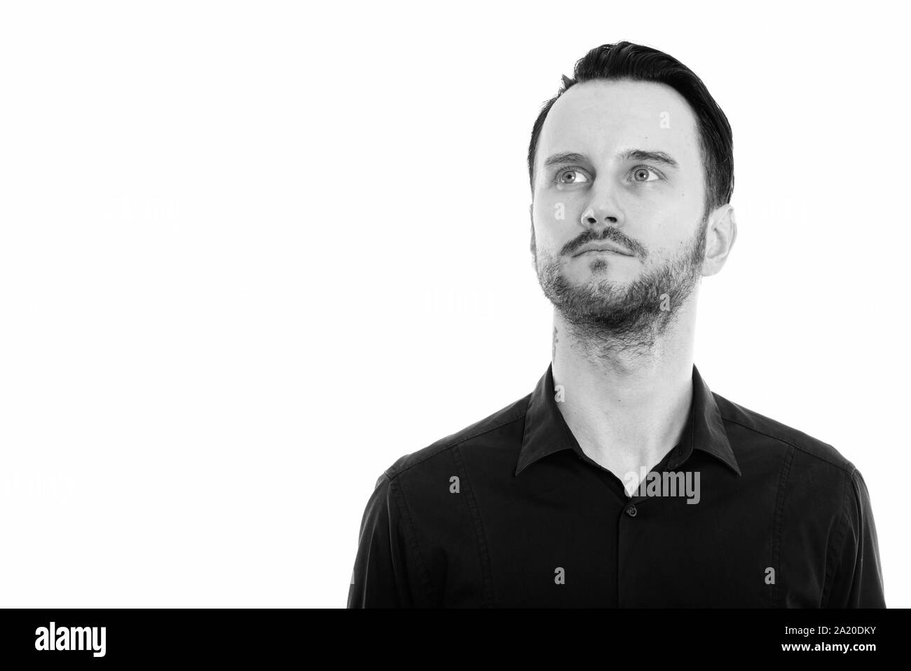 Studio shot of young man thinking while looking up Stock Photo - Alamy