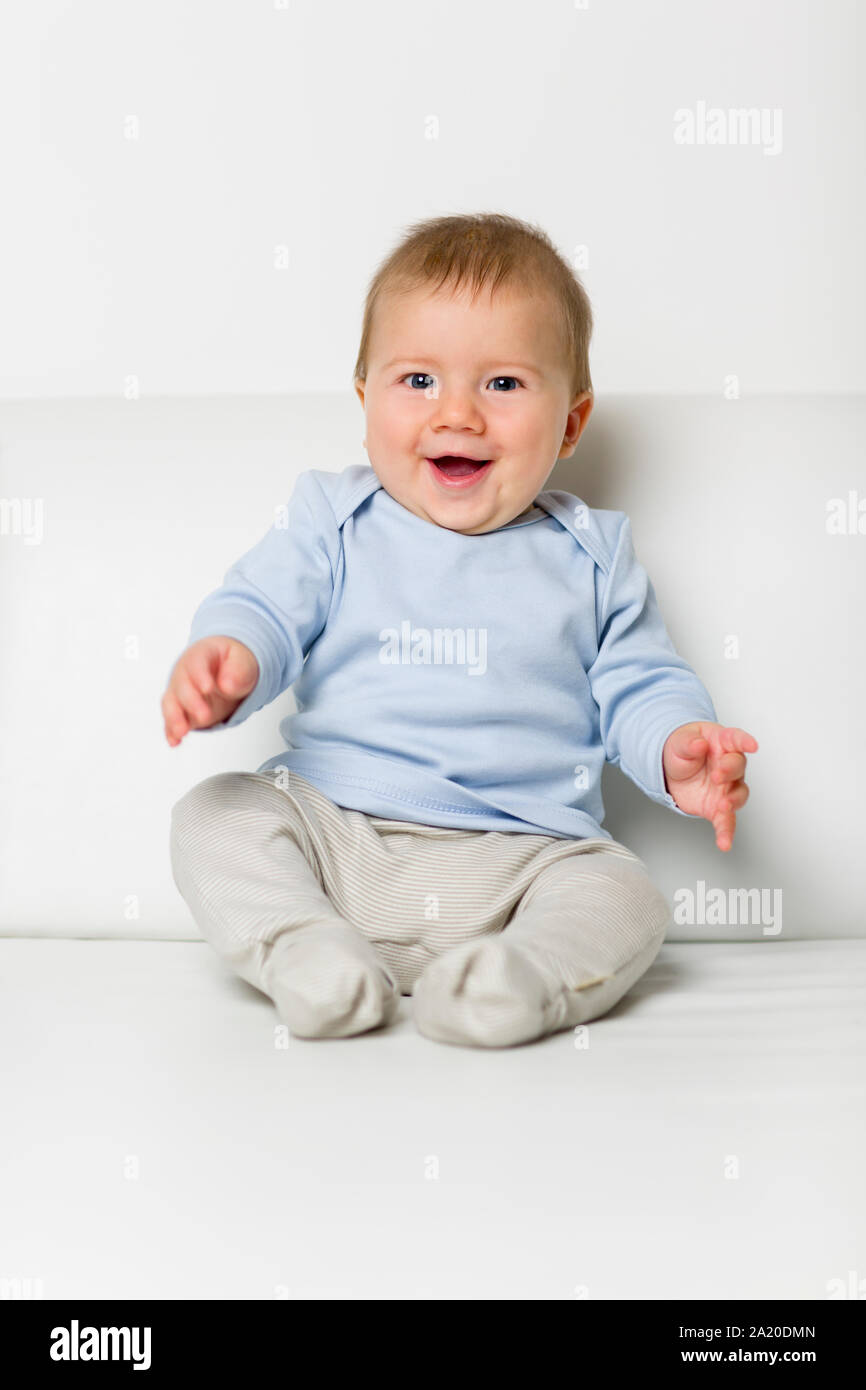 Portrait of sweet overjoyed baby boy sitting on sofa Stock Photo - Alamy
