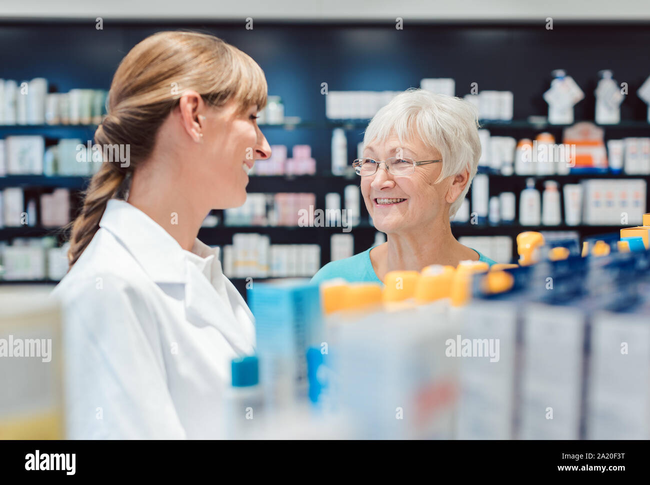 Chemist and customer standing in pharmacy between the shelves Stock ...