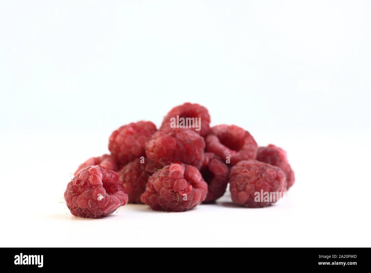 a pile of raspberry on white background Stock Photo - Alamy