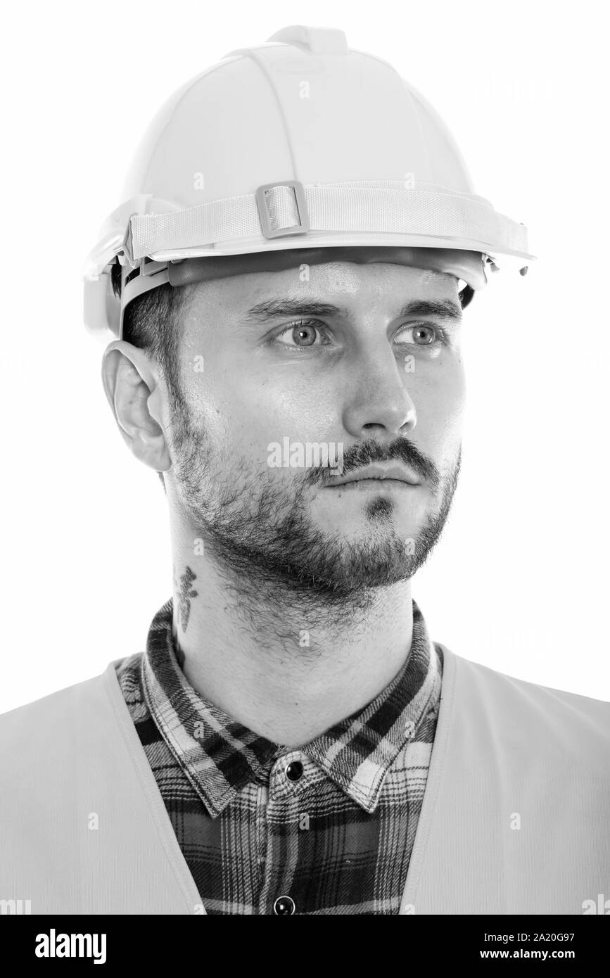 Face of young man construction worker thinking while looking at ...