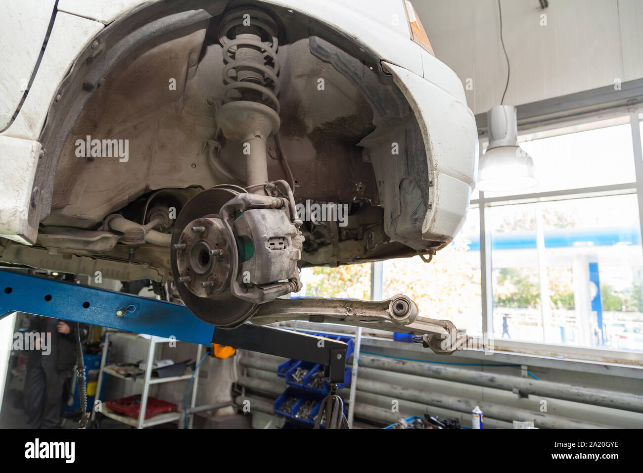 A close-up on the brake system and chassis of a white car with pads ...
