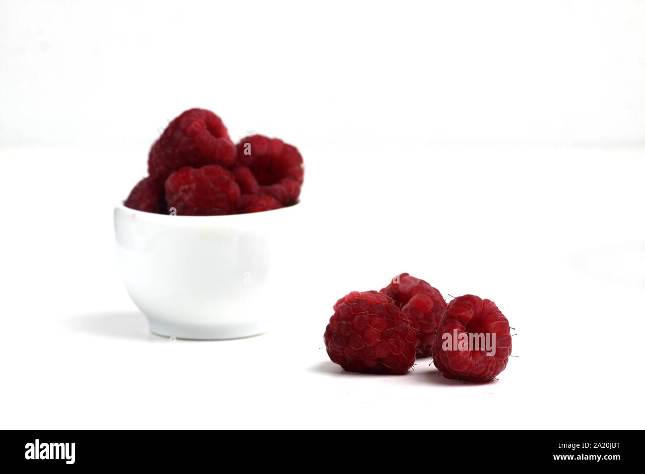 a bowl of raspberry on white background. Image contains copy space ...