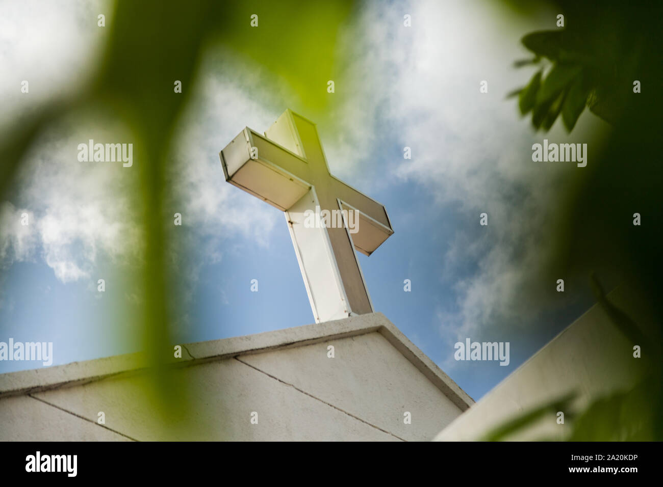 Faded red cross on church roof with leaves OOF in foreground Stock ...