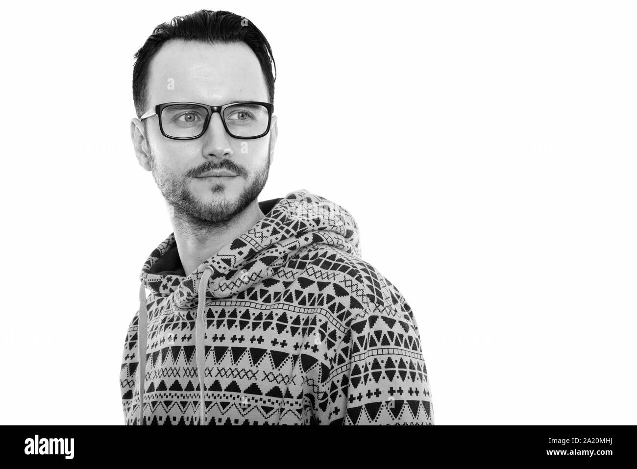 Studio shot of young man thinking while looking back and wearing ...
