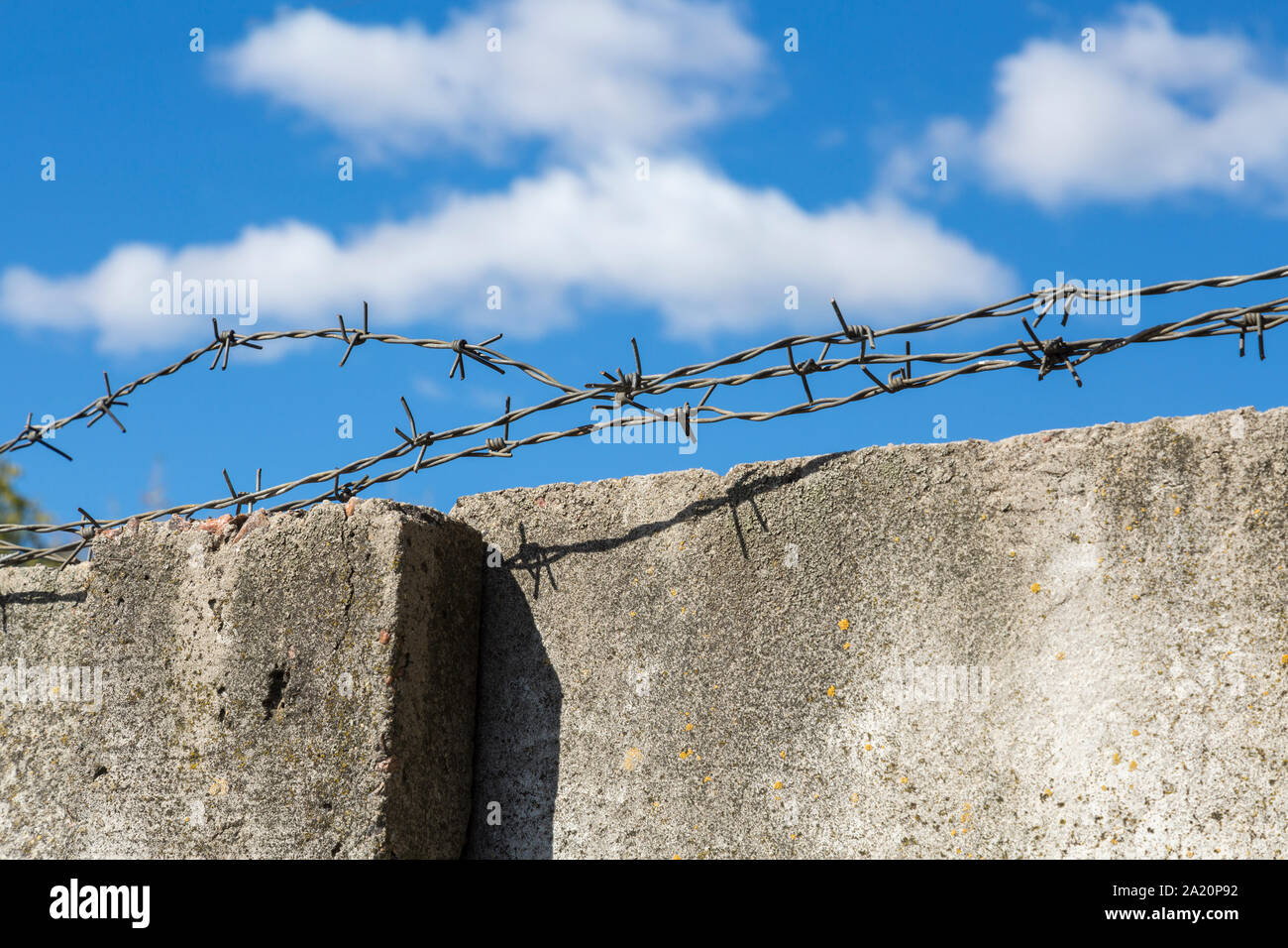 Three strands of barbed wire close-up, lying loosely on a fence of old ...