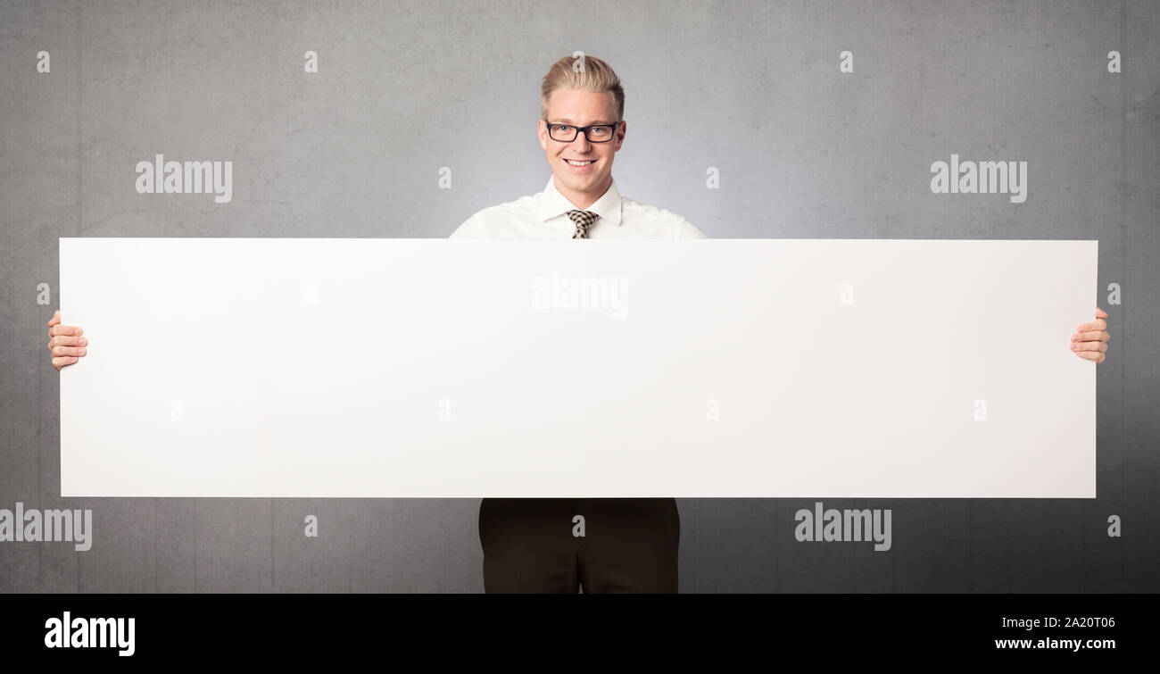 Smiling businessman showing white empty panel Stock Photo - Alamy
