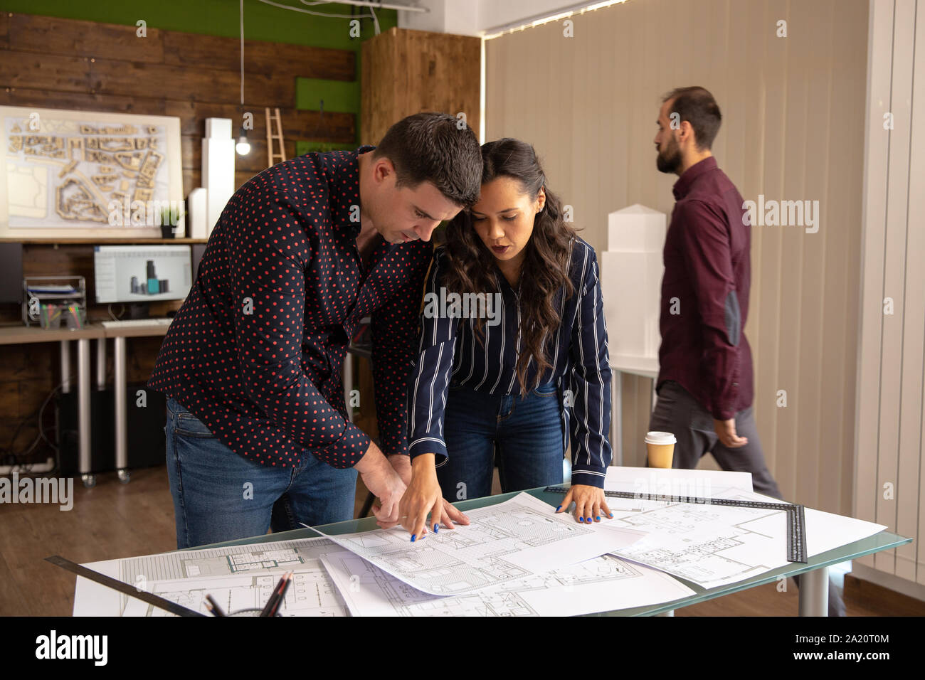 Two fellow architects standing at the table and discussing the project ...