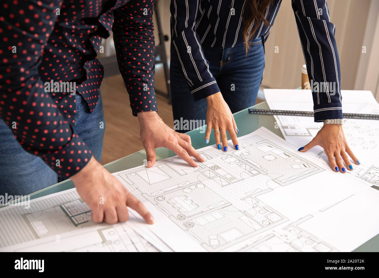 Close up with the hands of two architects pointing to a project plan ...