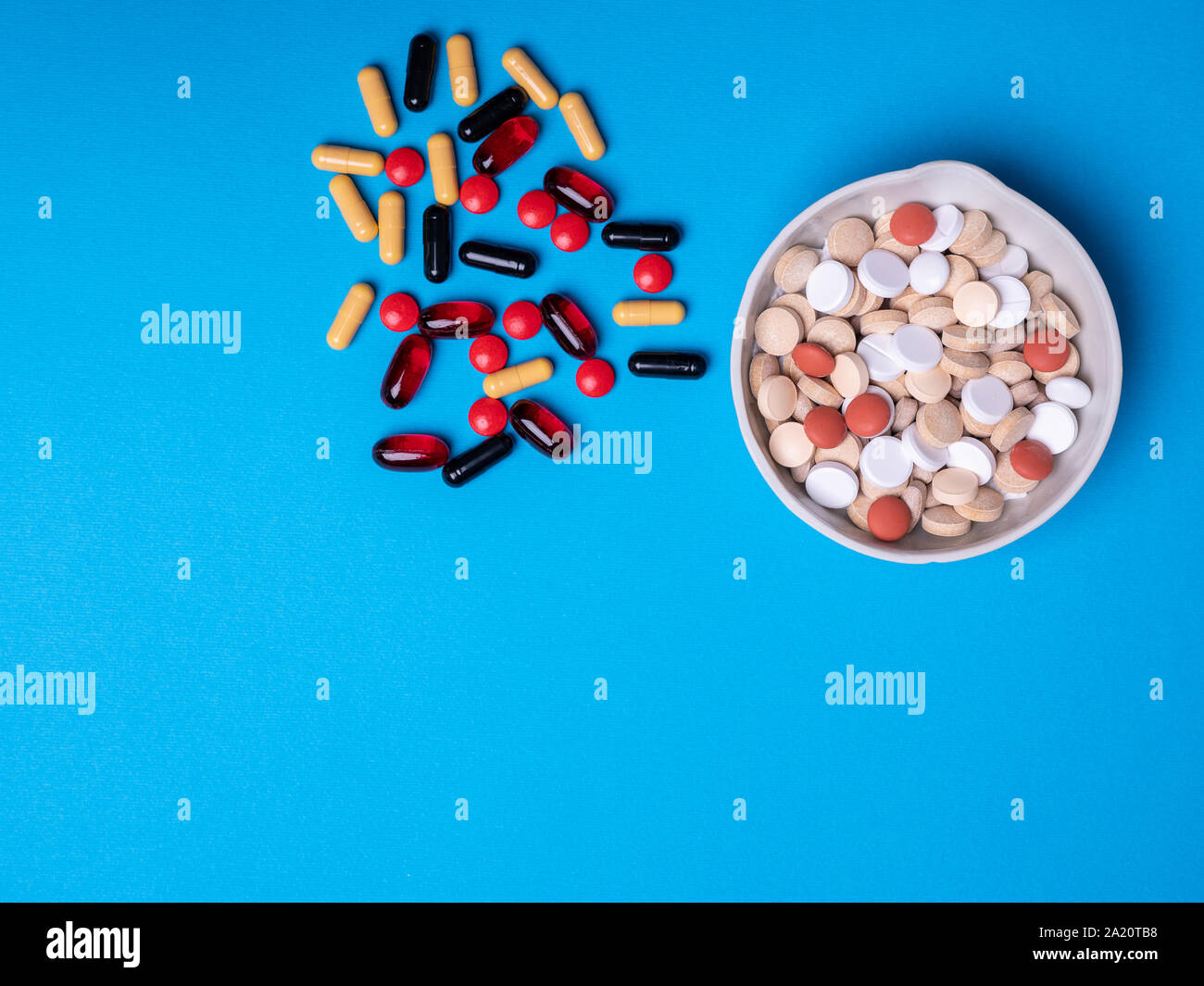Top view with a bowl of pills and next to other pills and capsules of ...