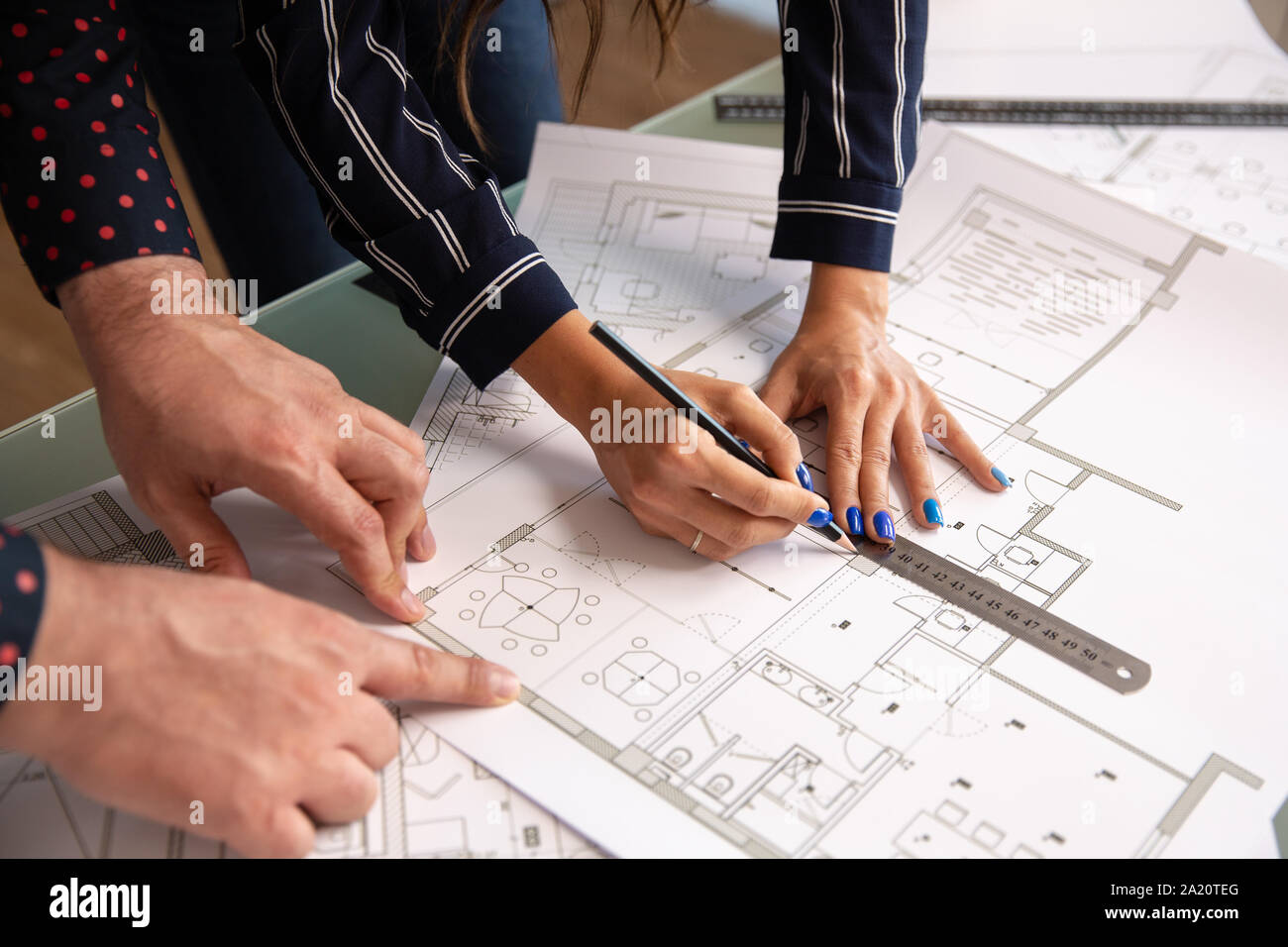 Close up with the hands of two architects sketching something in a ...