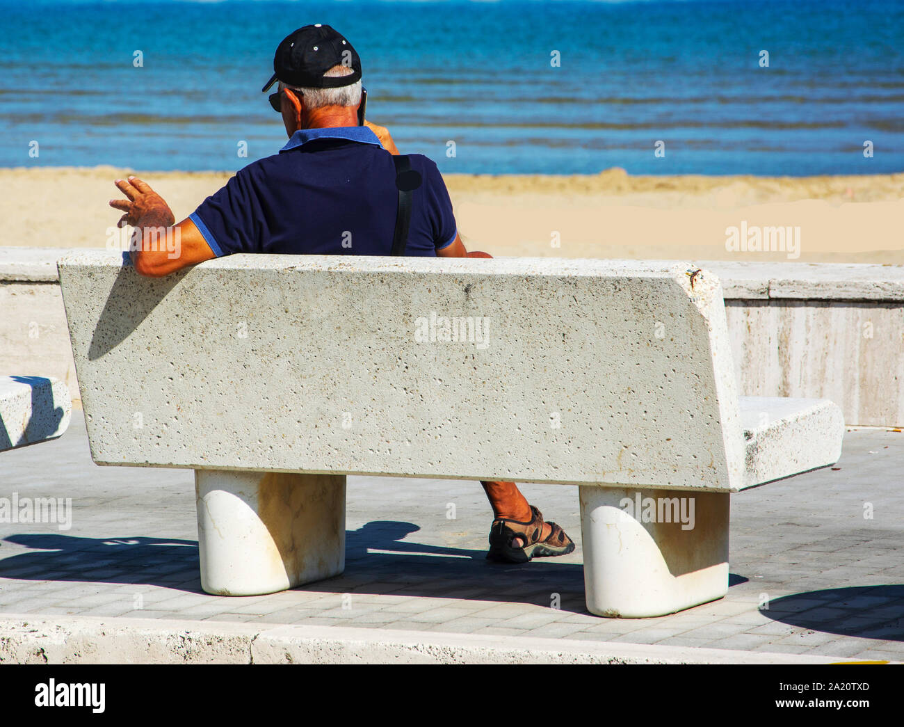 man sitting in a bench facing the sea Stock Photo - Alamy